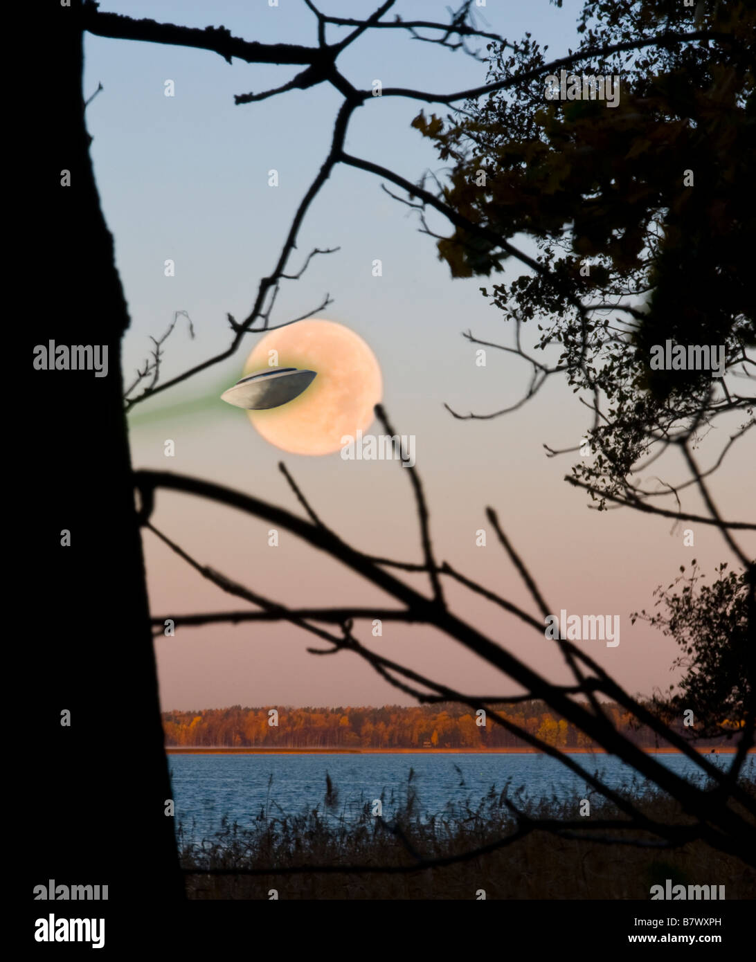 UFO flying in front of a big orange full moon Stock Photo - Alamy