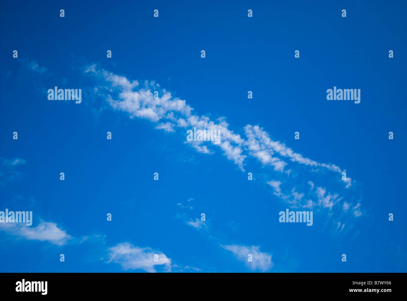 Small puffs of clouds in a bright vivid blue sky Stock Photo - Alamy