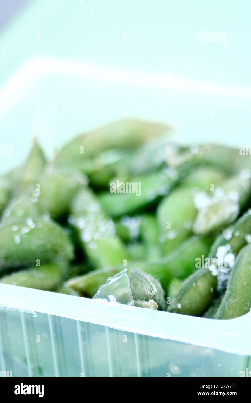 Soy Beans in a plastic pale with rock salt on top against a light blue ...