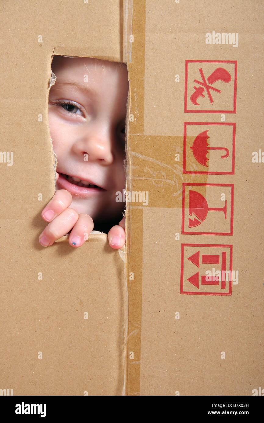 young girl looking from brown carton box Stock Photo - Alamy