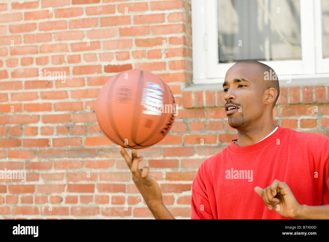 Young man balancing basketball on finger Stock Photo - Alamy
