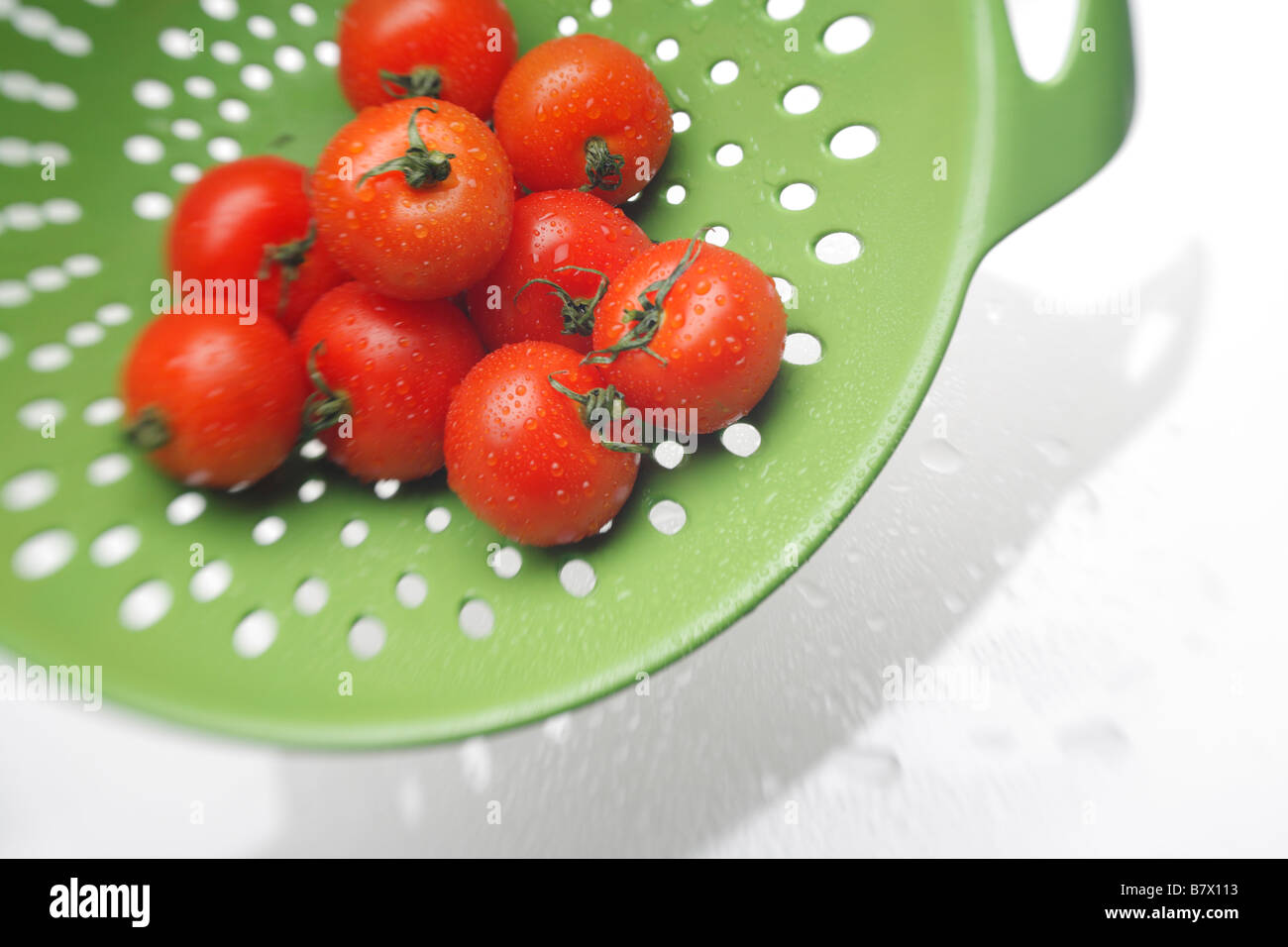 Cherry tomatoes in colander washed, studio shot Stock Photo - Alamy