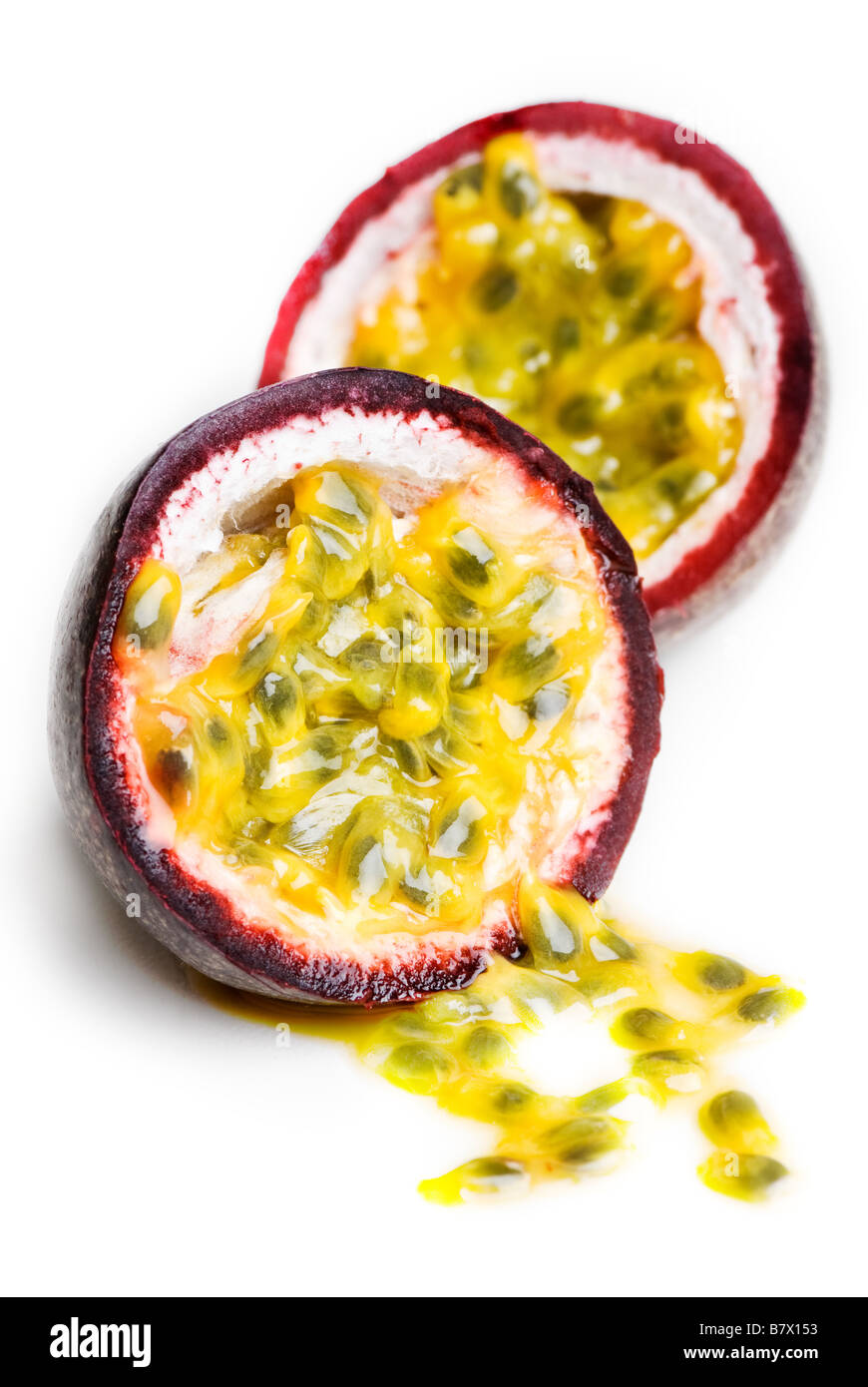 A passionfruit split in half with the seeds falling out Stock Photo - Alamy
