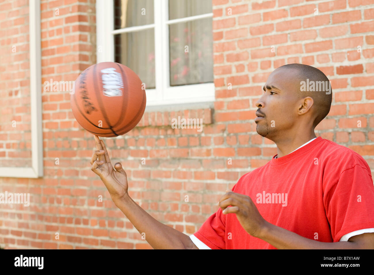 Young man balancing basketball on finger Stock Photo - Alamy
