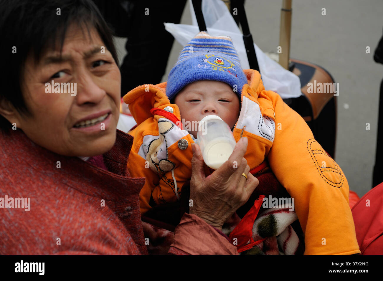 An elder woman feeds a baby with powdered milk in Nanchang, Jiangxi ...