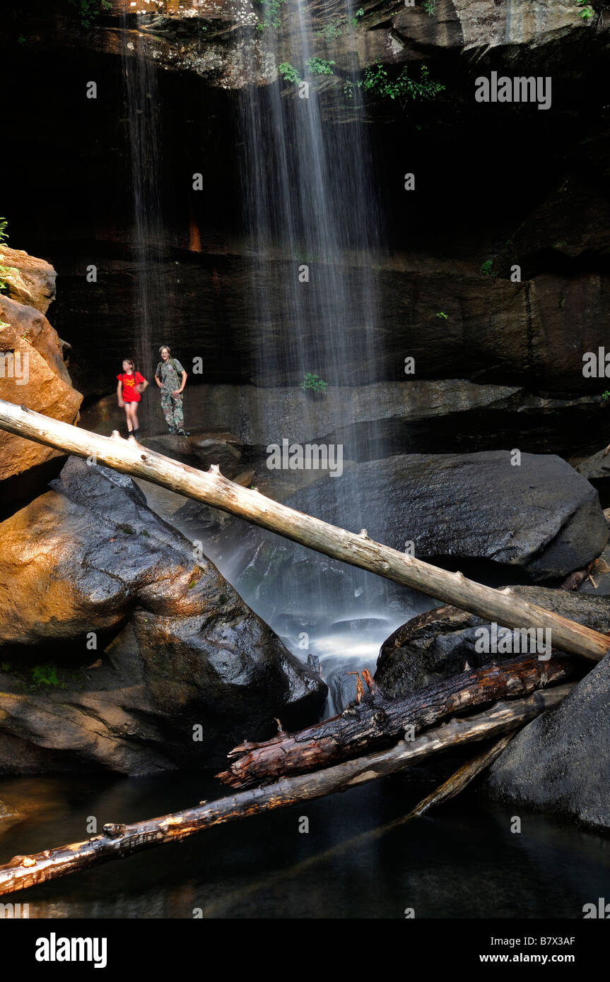 two people standing behind Eagle Falls waterfall at Cumberland Falls ...