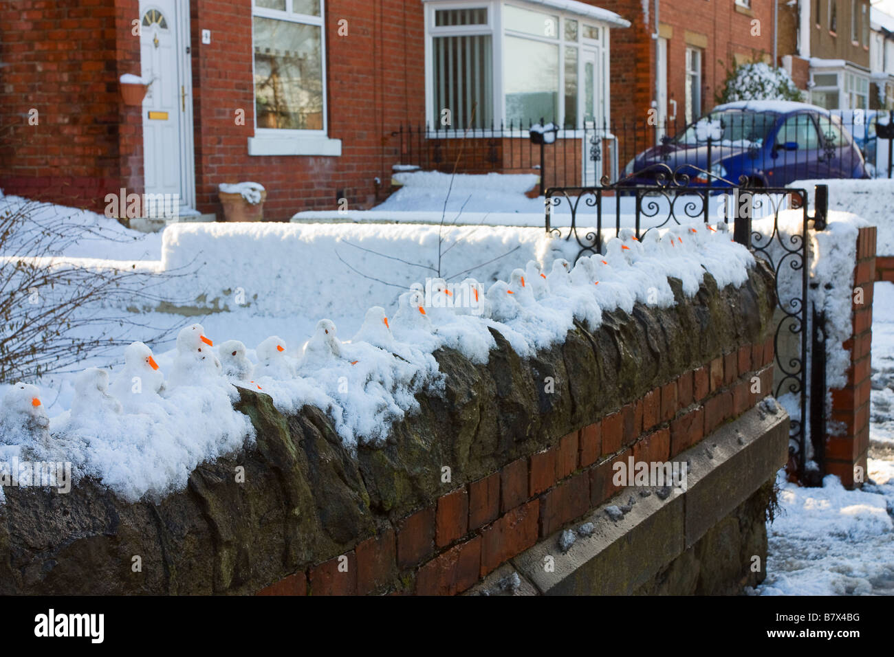 a line of mini snowmen with orange noses lined up on wall Stock Photo ...