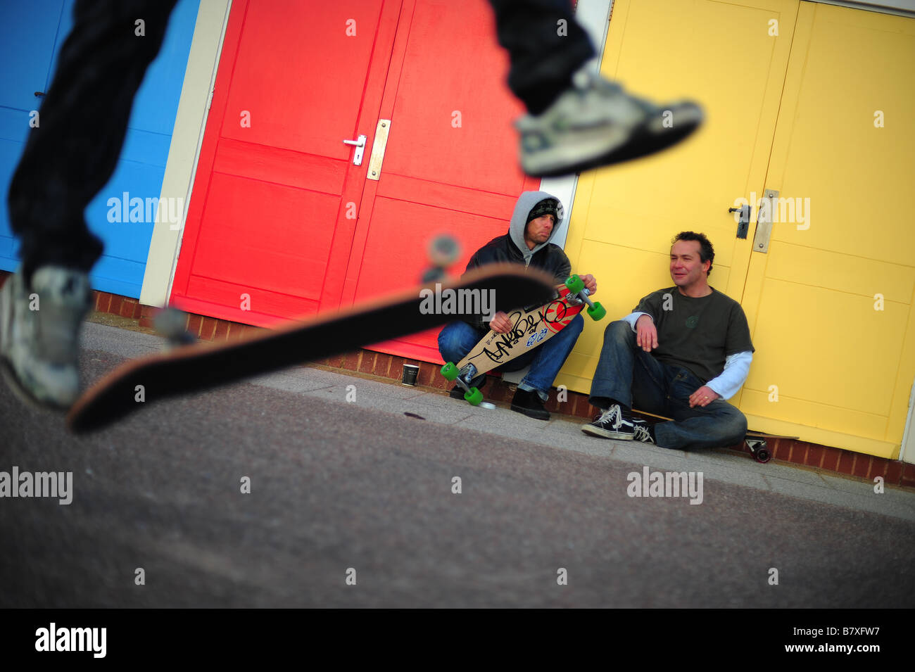 men skateboarding and sitting on the promenade at Exmouth, Devon , UK ...