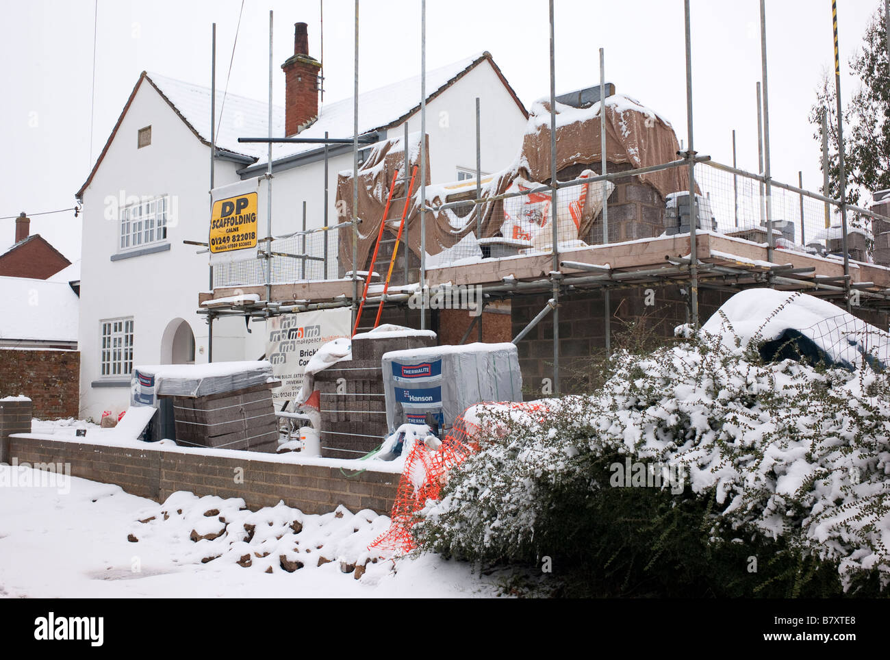 House construction stopped by winter snowfall viewed from public road ...