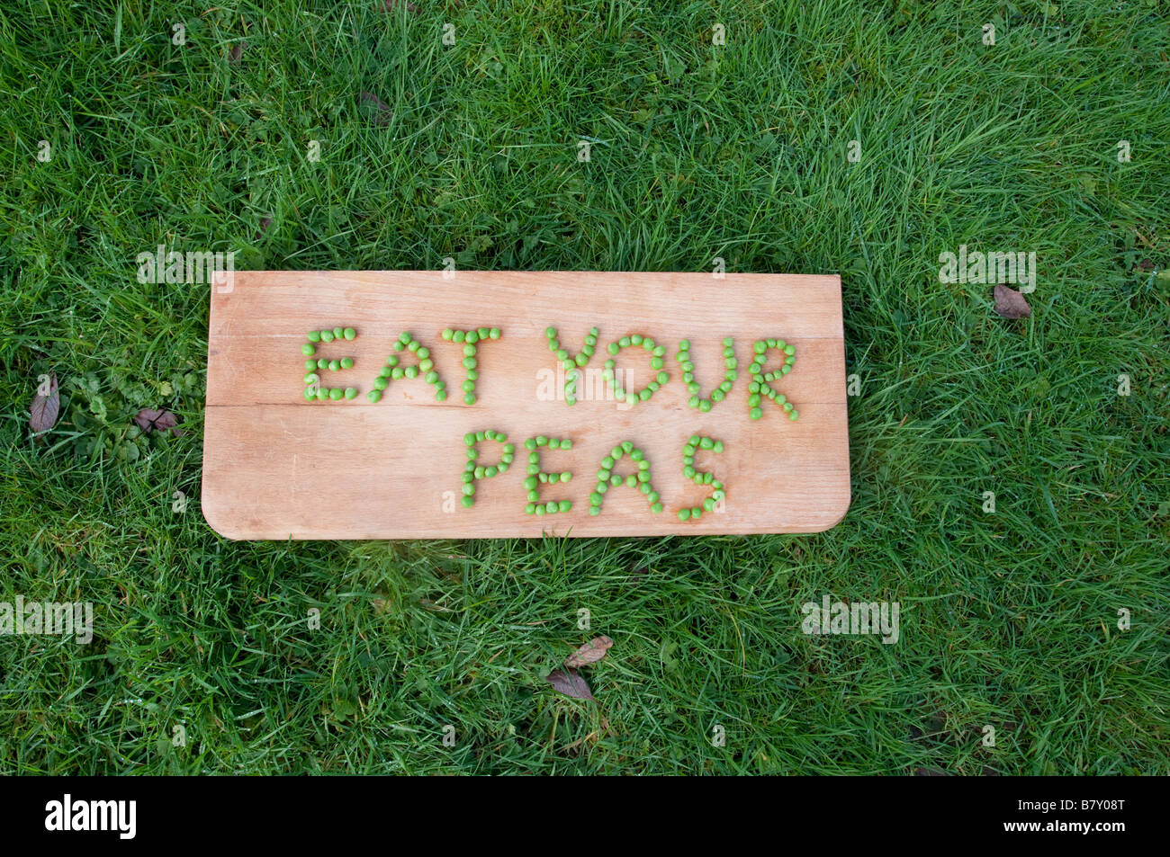Eat your peas spelt out in peas on a chopping block Stock Photo - Alamy