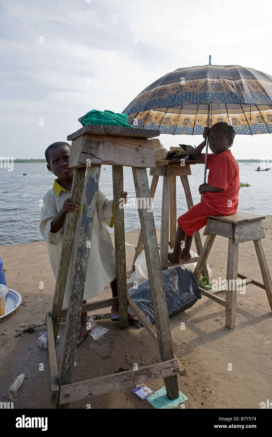 Two young Nigerian children look in mild trepidation at the ...