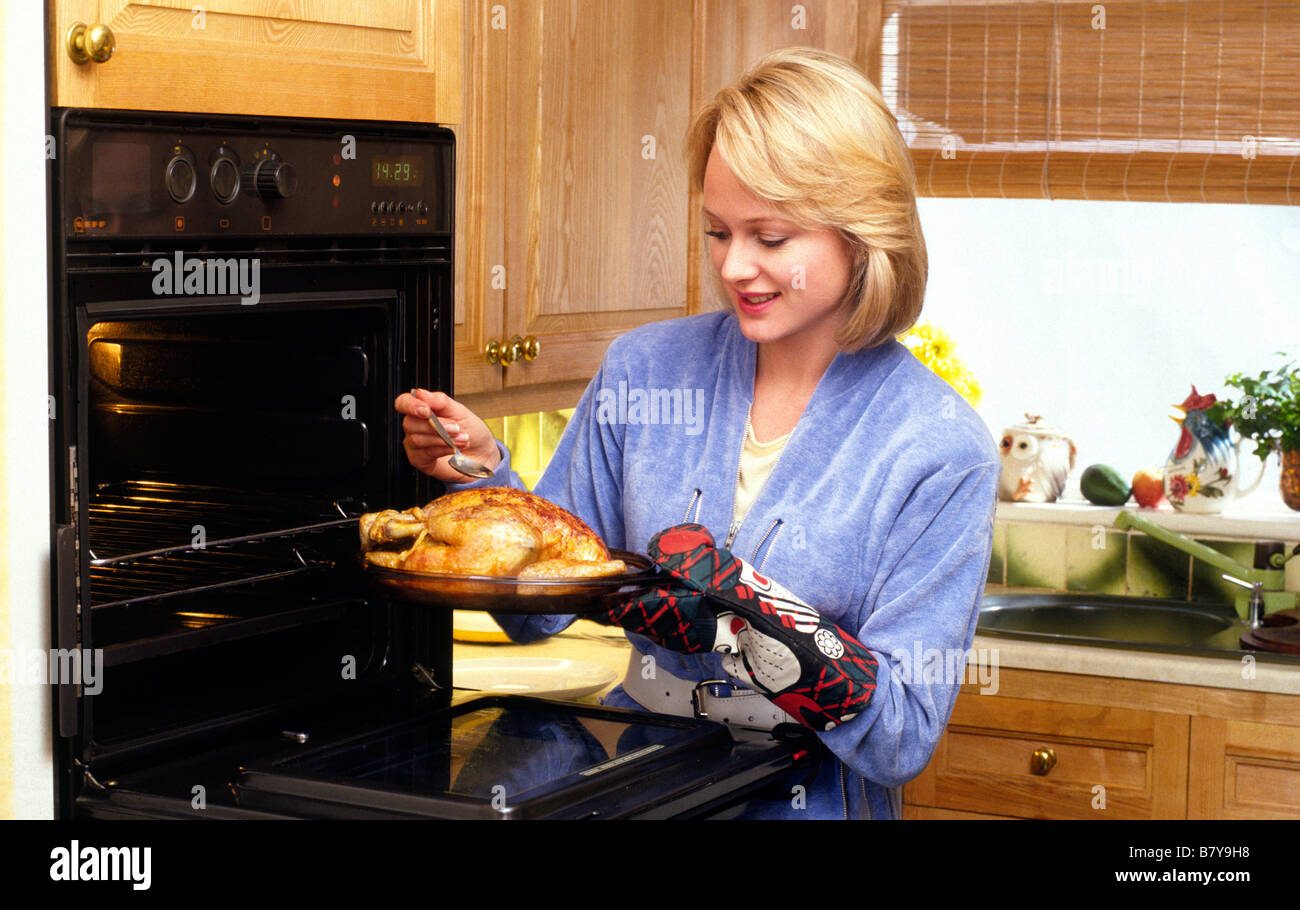 Cooking and basting a chicken in the kitchen Stock Photo - Alamy