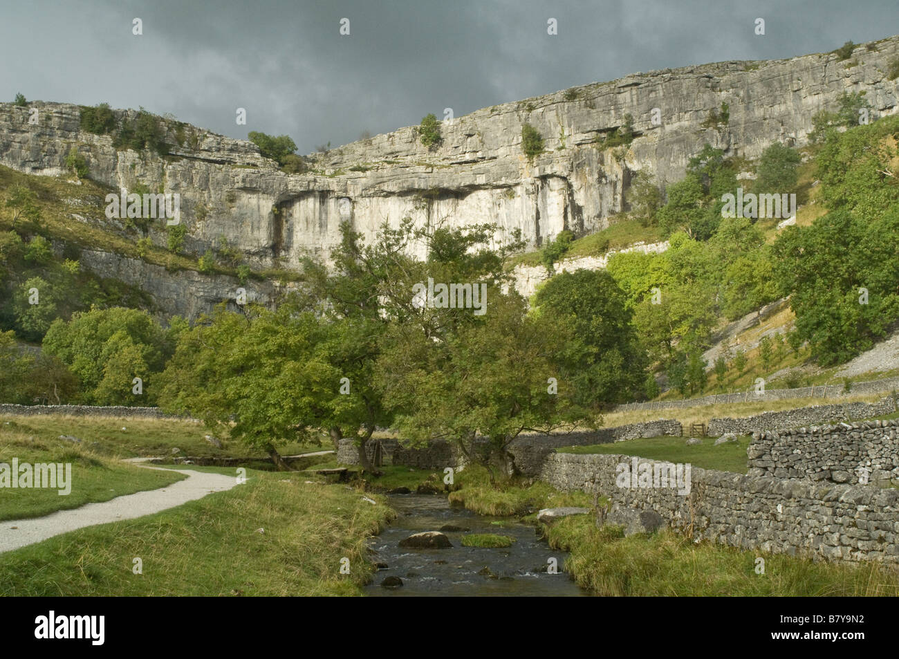 The limestone cliff of Malham Cove in the Yorkshire Dales with a stormy ...