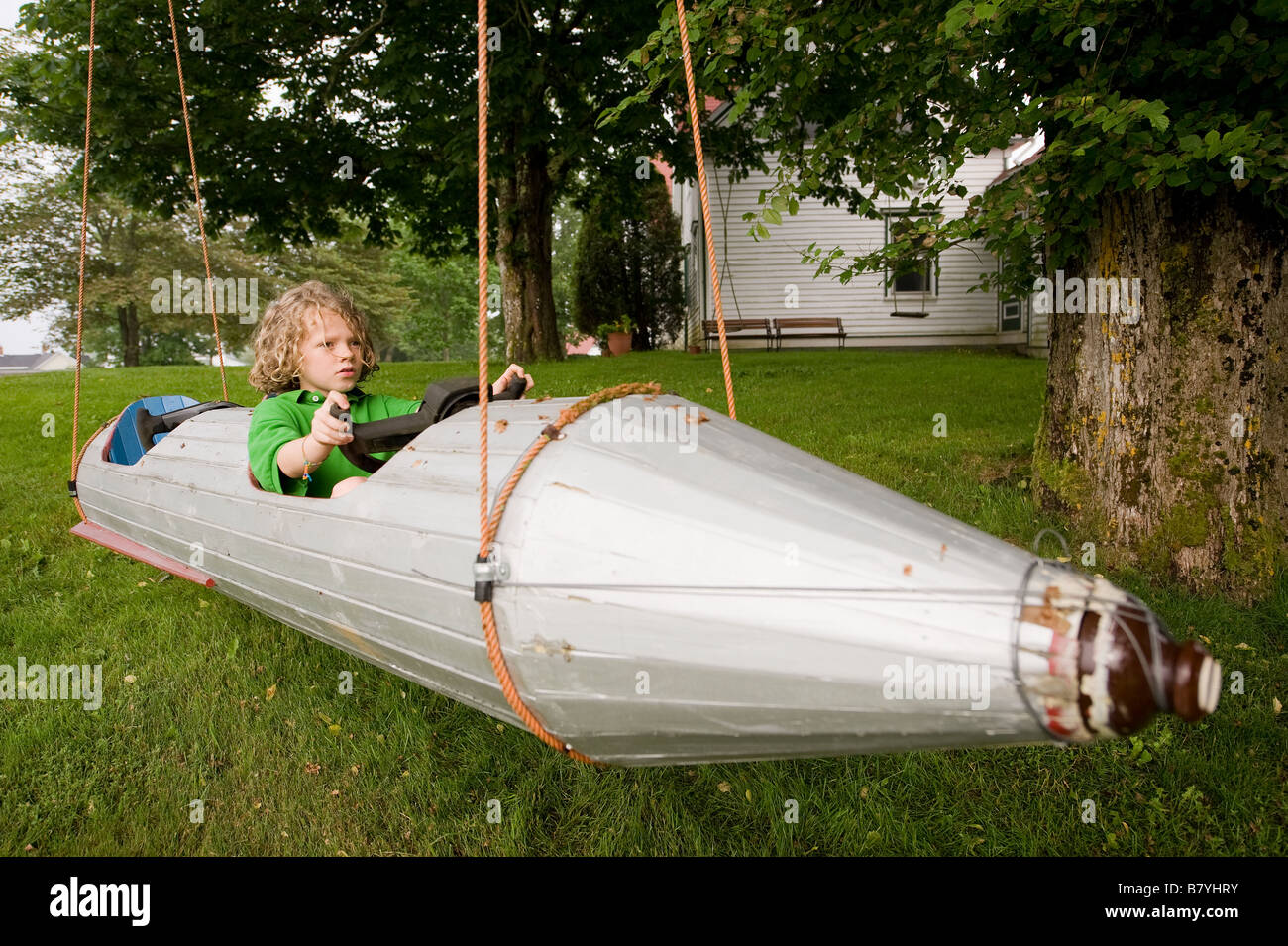 A young boy pretends to fly in a swing space ship Stock Photo - Alamy