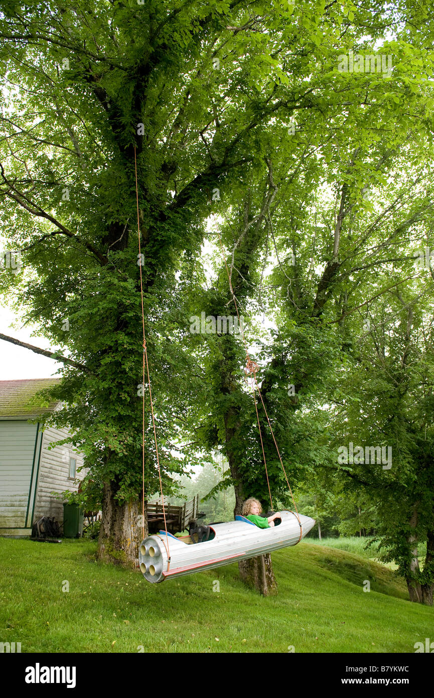 Little boy flies around in a spaceship hanging from a tree Stock Photo ...