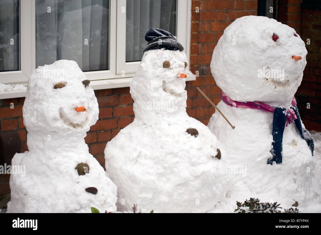 Three snowman outside a Suburban London House Stock Photo - Alamy