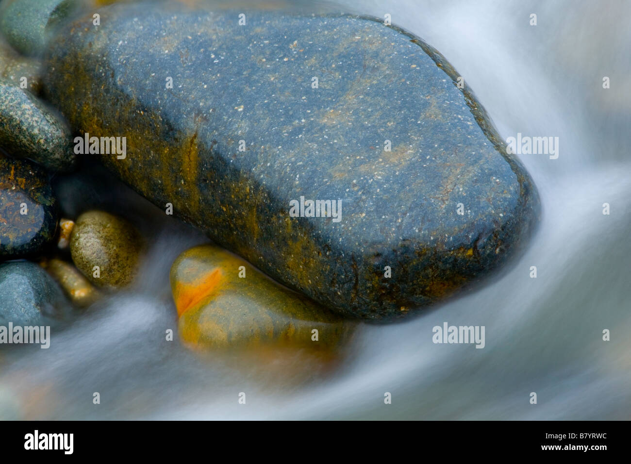 Water flowing around a large stone Stock Photo - Alamy