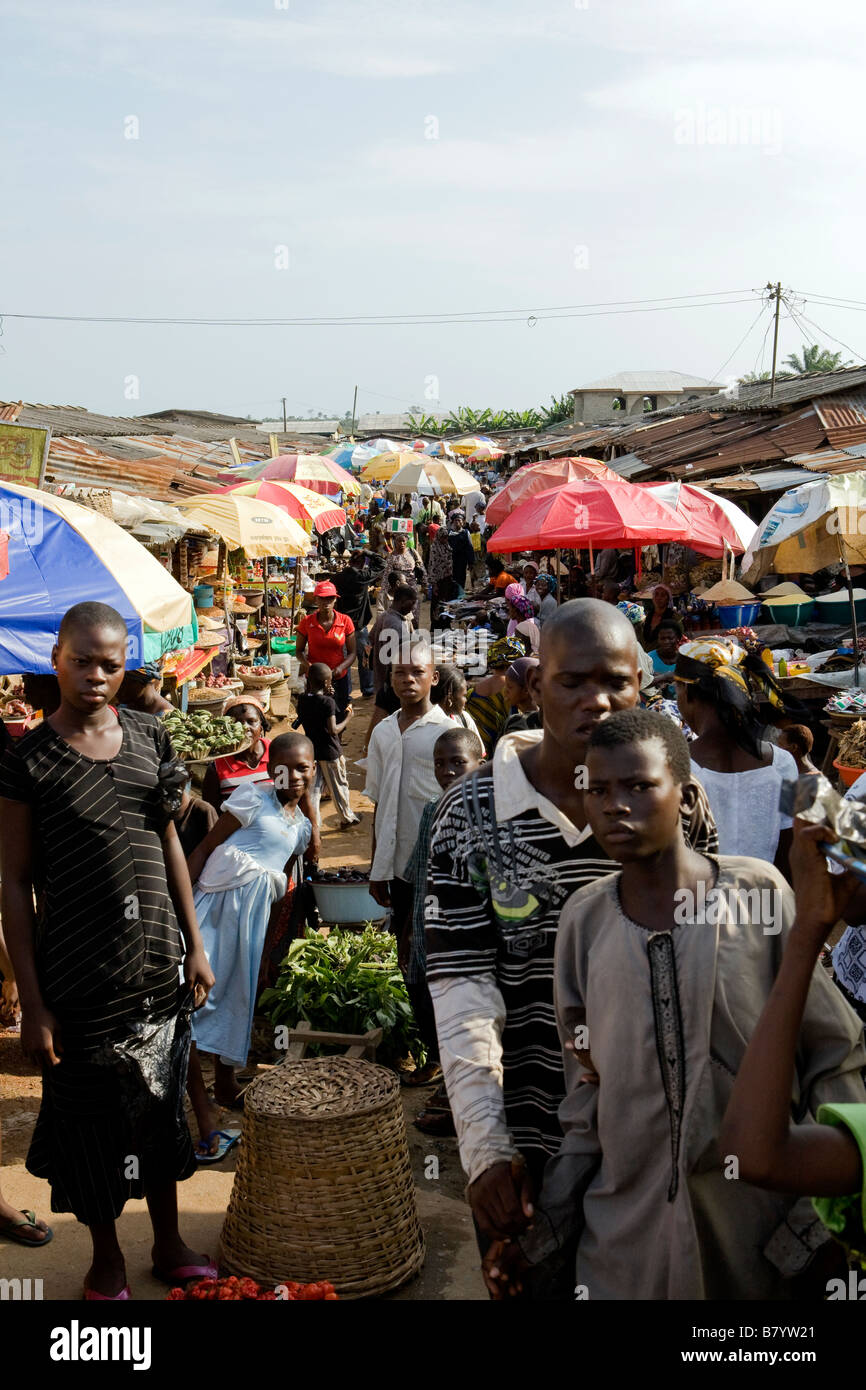 A crown of local shoppers at Poka market in Nigeria look strangely at ...