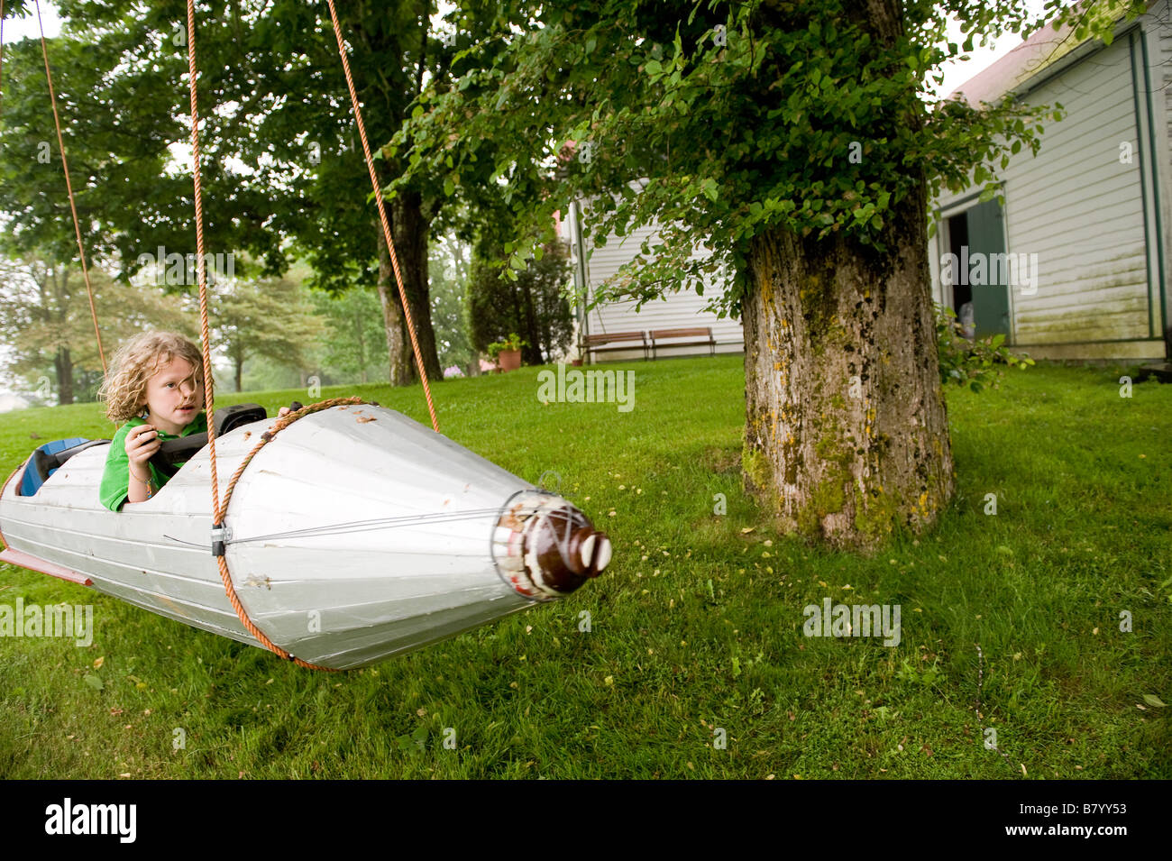 Little boy flies around in a spaceship hanging from a tree Stock Photo ...