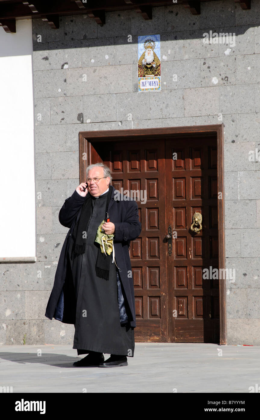 Catholic priest using a mobile phone standing outside a church Stock ...