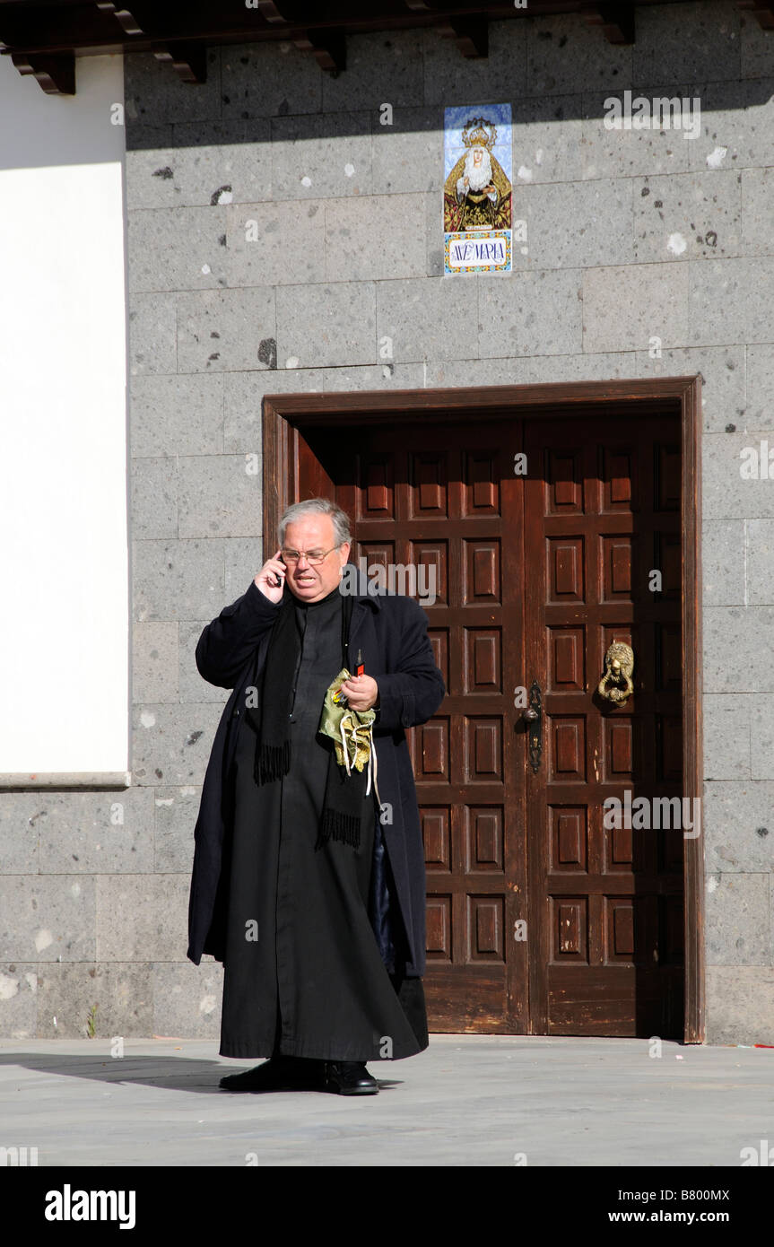 Catholic priest using a mobile phone standing outside a church Stock ...