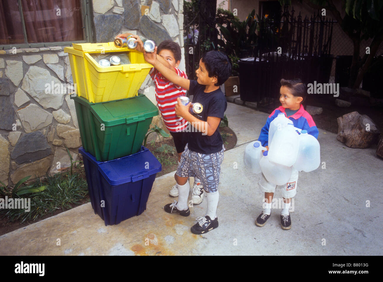 Three Hispanic boys recycle trash and waste ecology environment ...