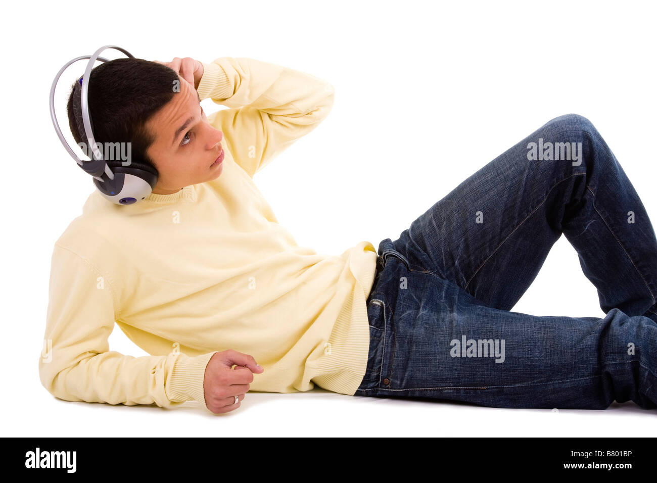 young man lie down on the floor relaxing at the sound of good music ...