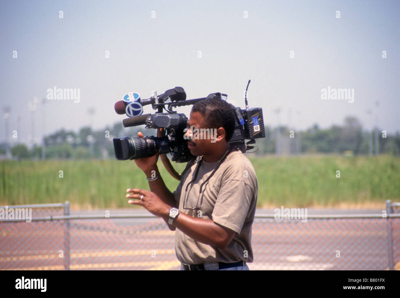 Black television cameraman prepares to record video Stock Photo - Alamy