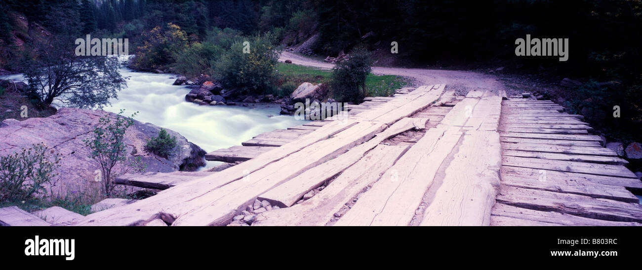Wooden make-shift bridge over the waterflow of a high altitude mountain ...