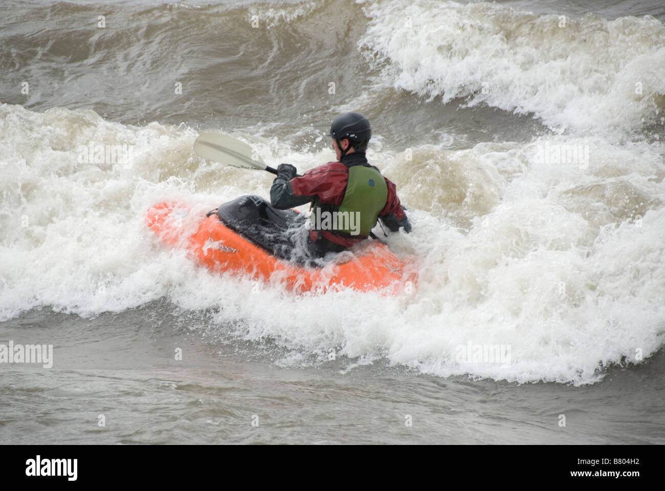 Young man in a kayak fighting the waves in a wild river Stock Photo - Alamy