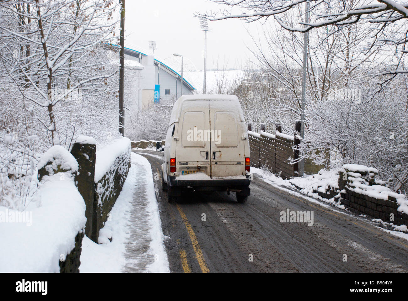 white van driving down a snow covered road Stock Photo - Alamy