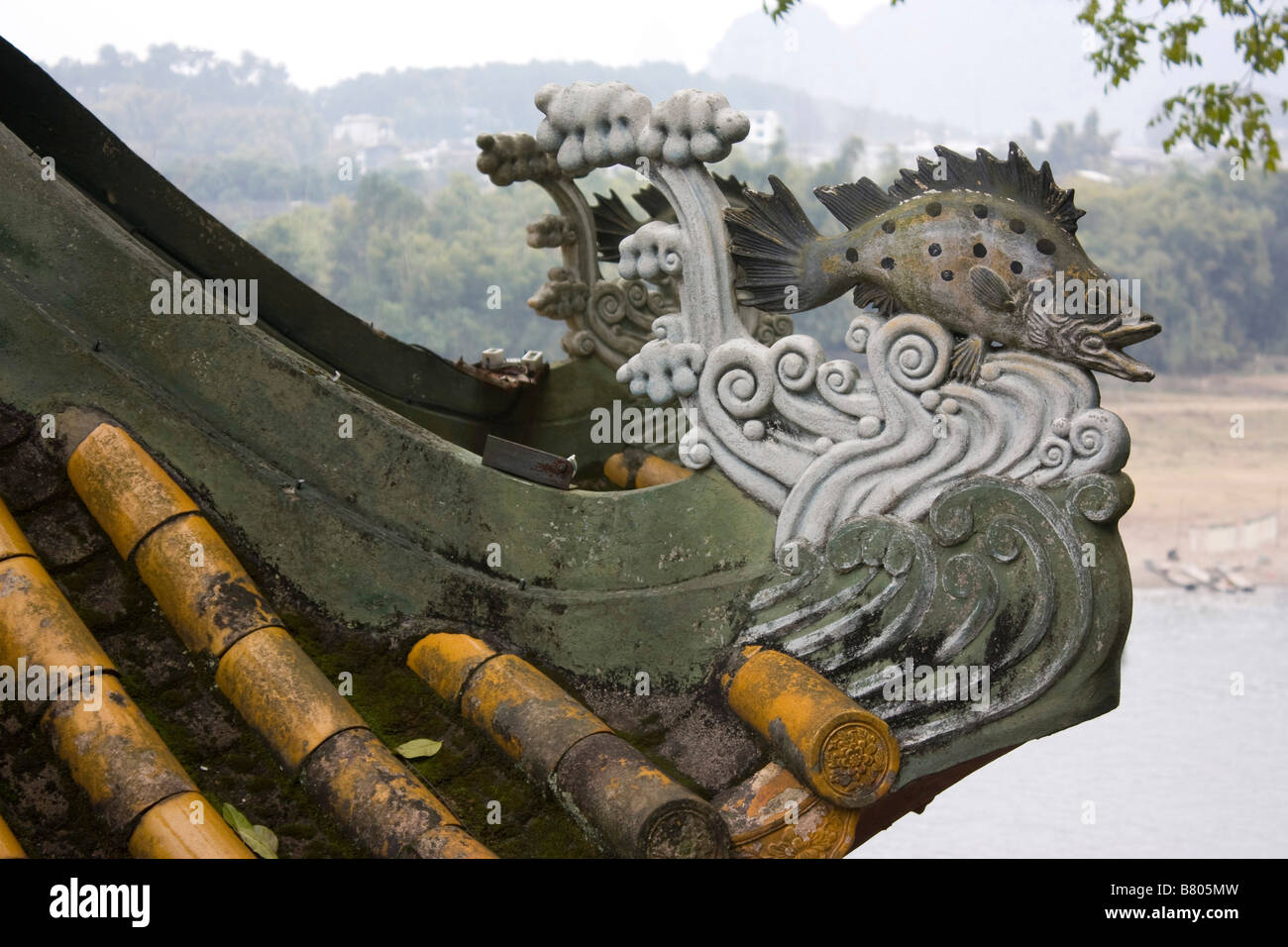 Fish carved from stone decorating the edge of the roof in a typical ...