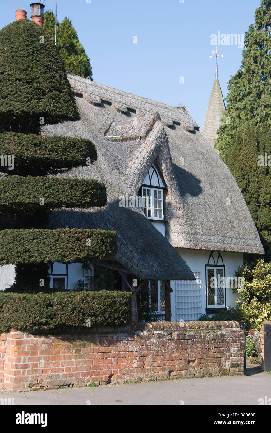 Yew Tree Cottage, Birdbrook, Essex, UK. A neatly clipped yew gives this ...