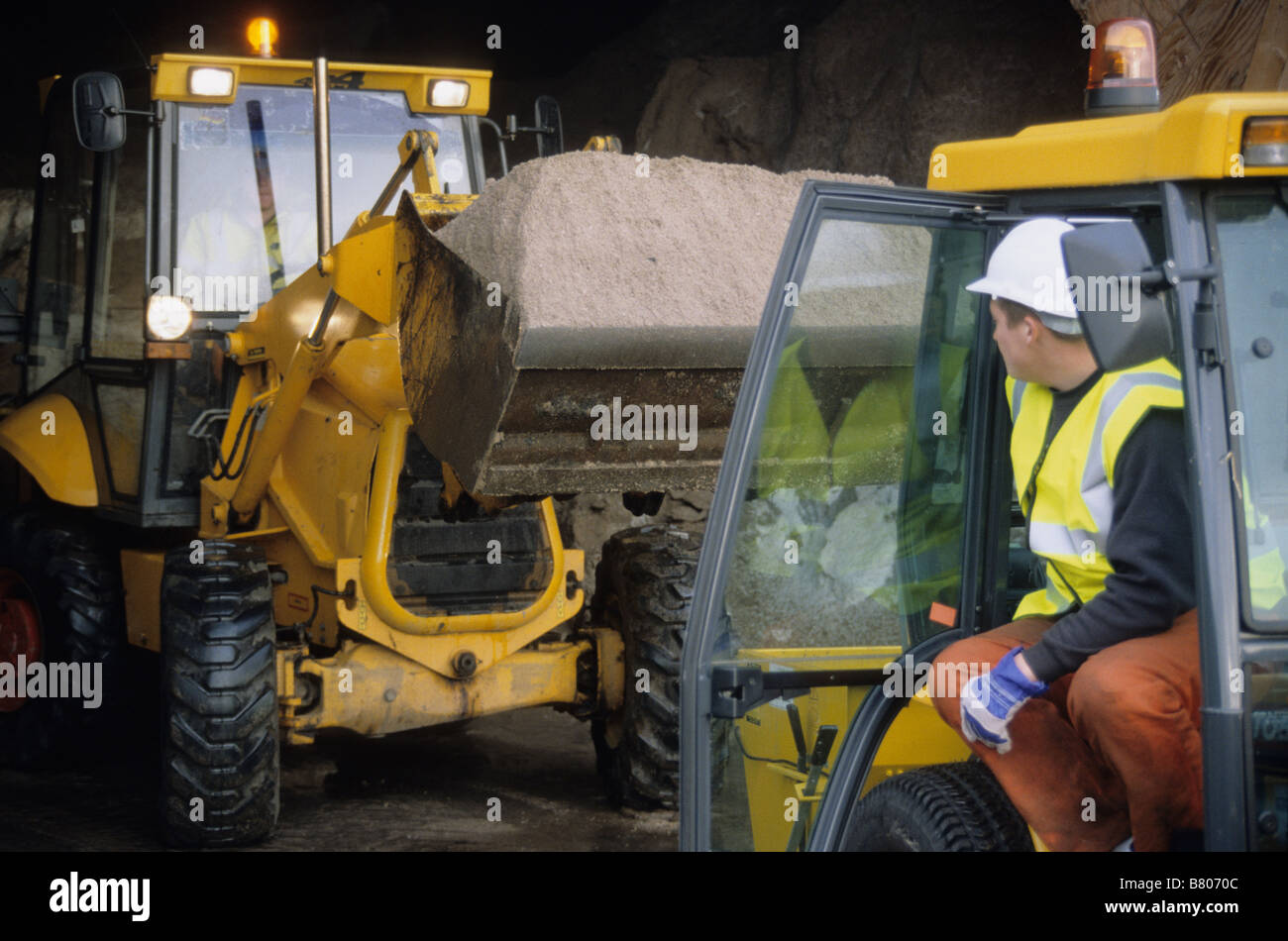 digger loading rock salt for road gritting Stock Photo - Alamy