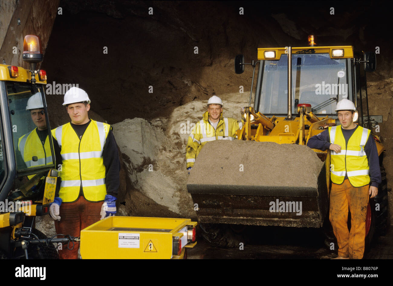 workers with digger loading rock salt for road gritting Stock Photo - Alamy