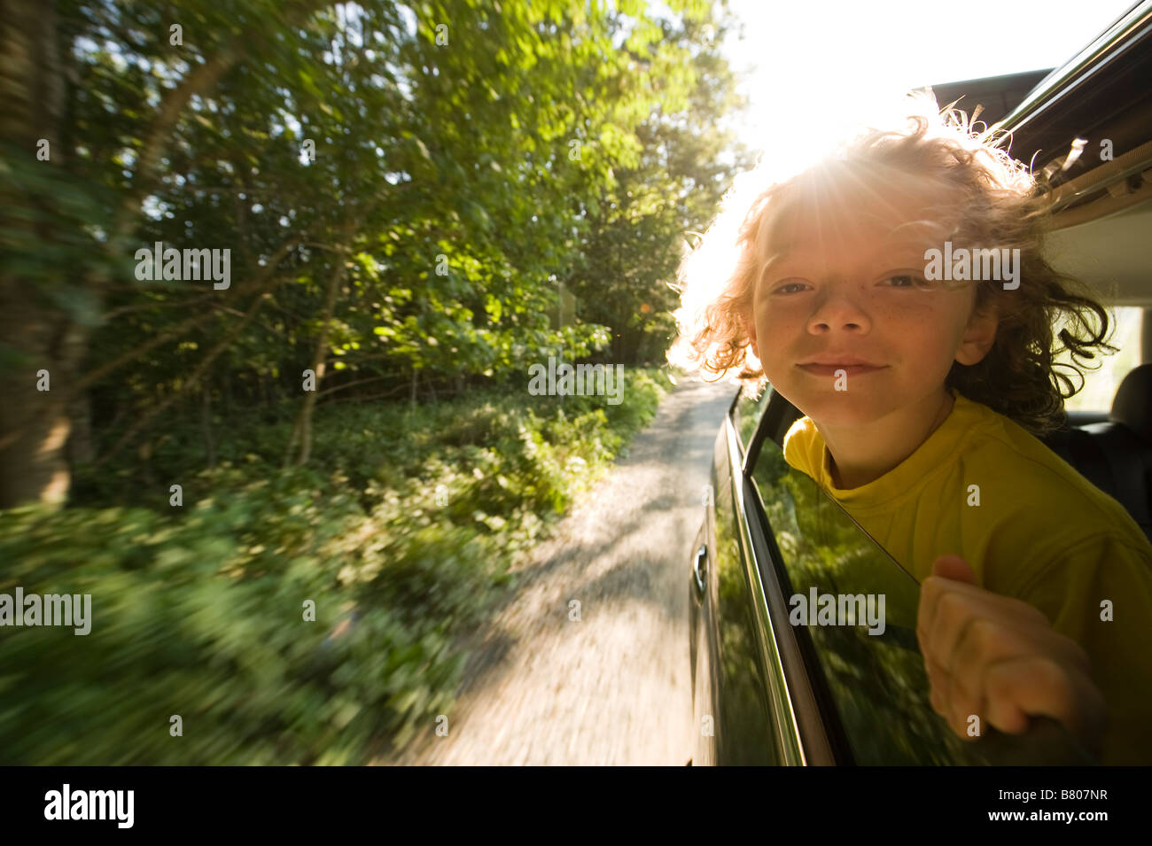 A young boy sticks his head out of the window during a drive Stock ...