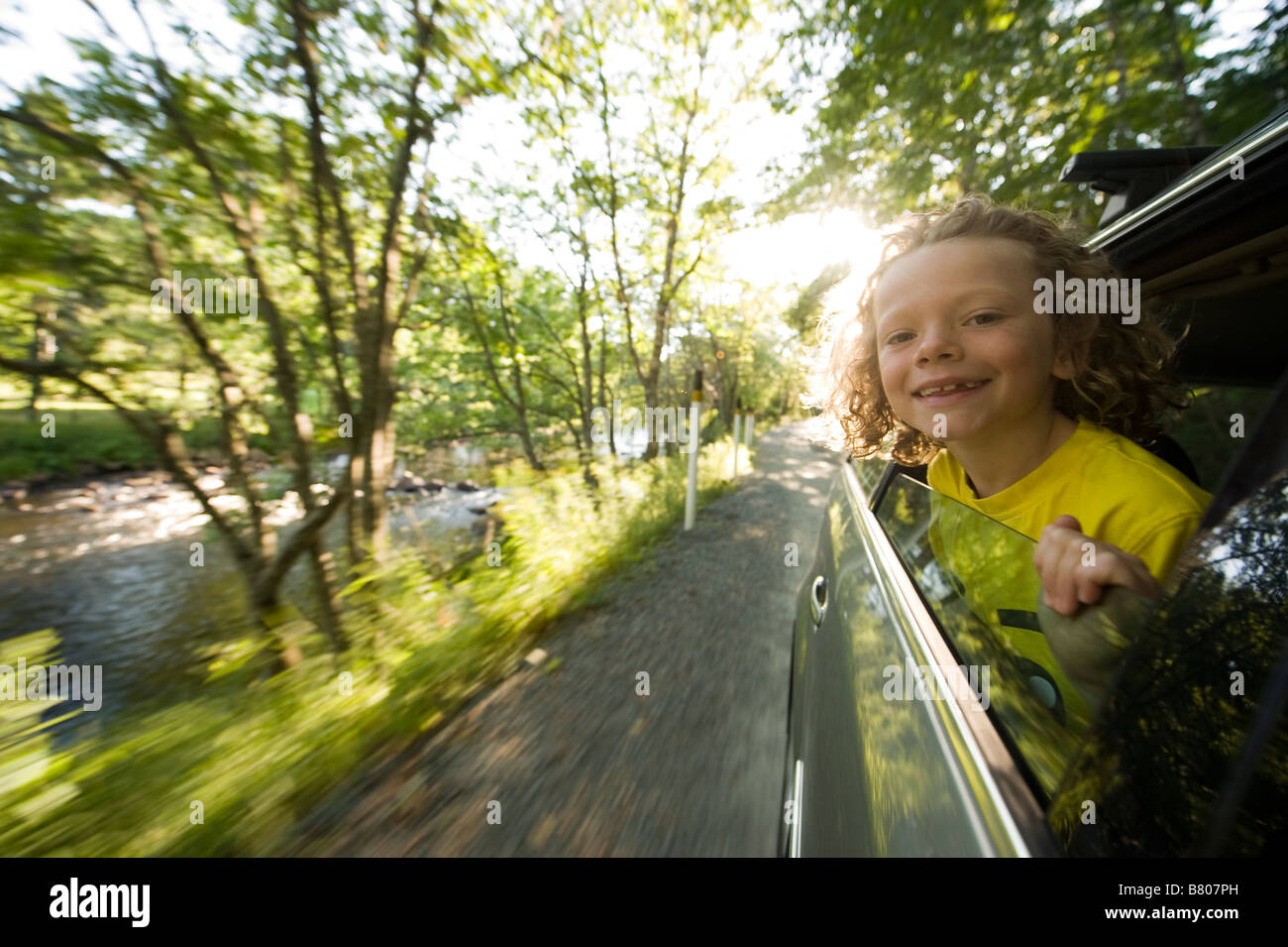 A young boy sticks his head out of the window during a drive Stock ...