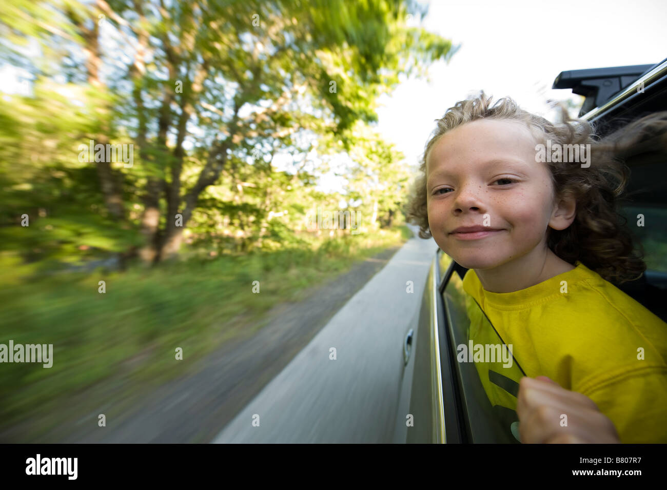 A young boy sticks his head out of the window during a drive Stock ...