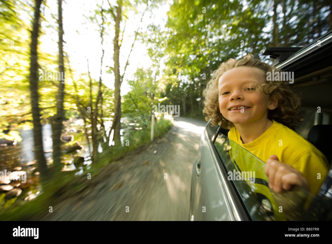 A young boy sticks his head out of the window during a drive Stock ...