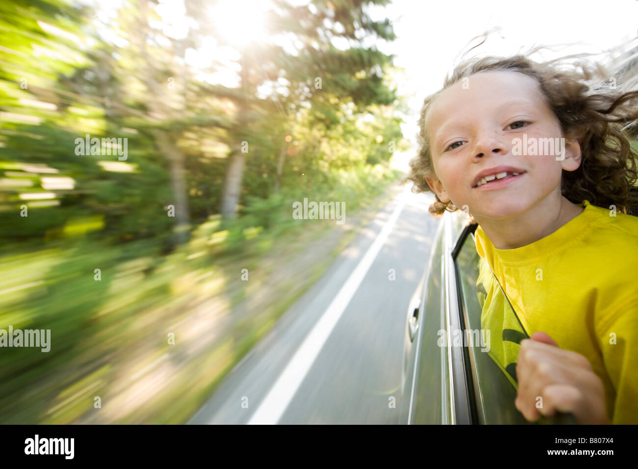 A young boy sticks his head out of the window during a drive Stock ...