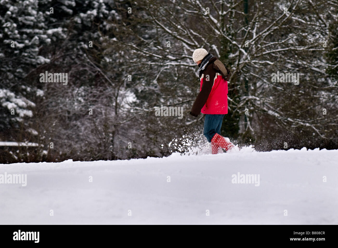 A young female walking through snow Stock Photo - Alamy