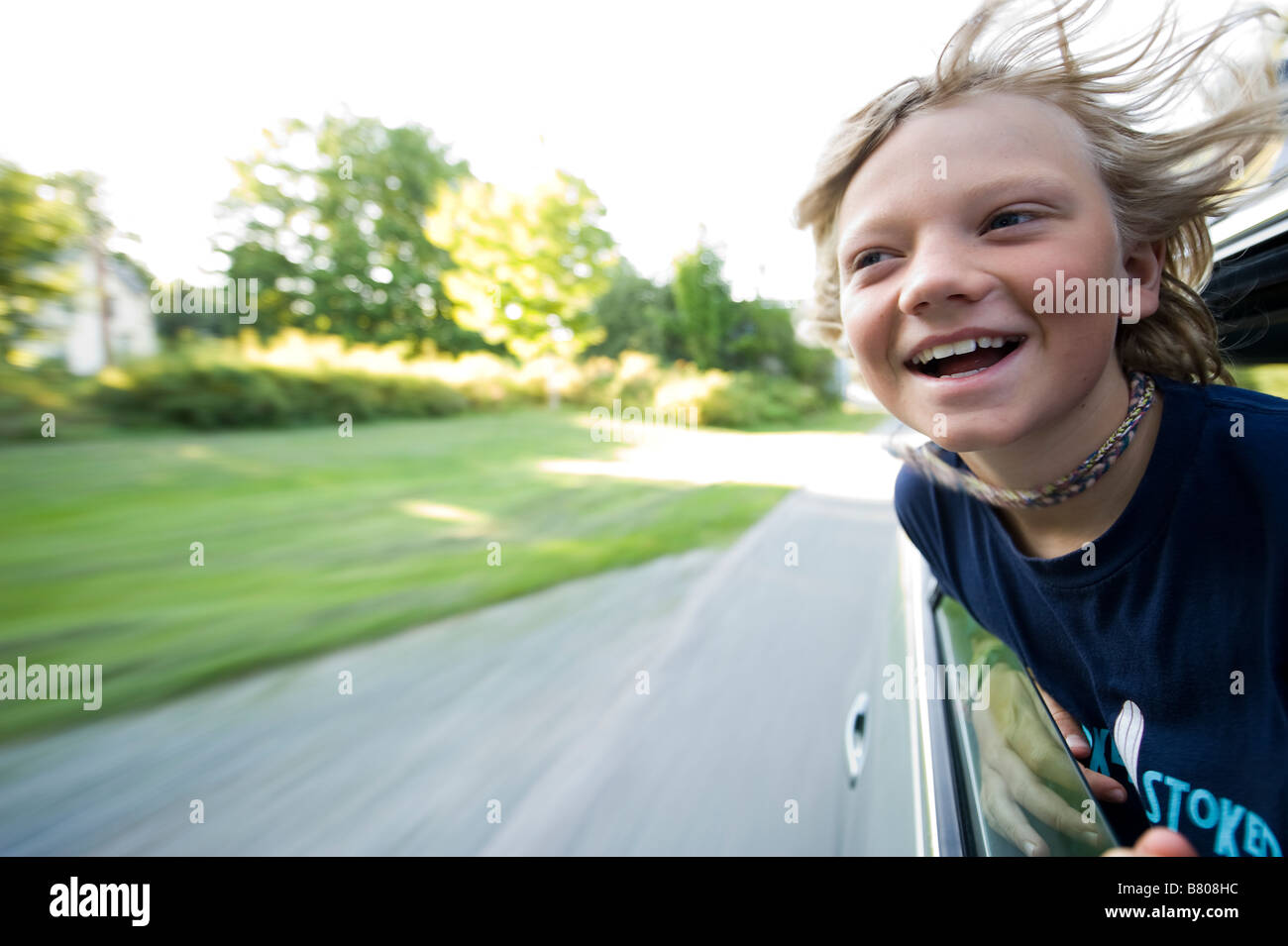 A young boy sticks his head out of the window during a drive Stock ...