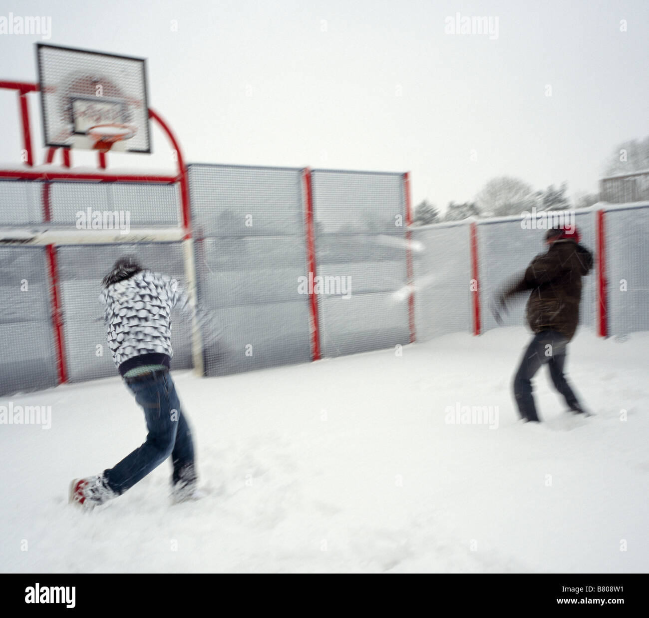 Action shot of two teenage boys having a snowball fight in a snow storm ...