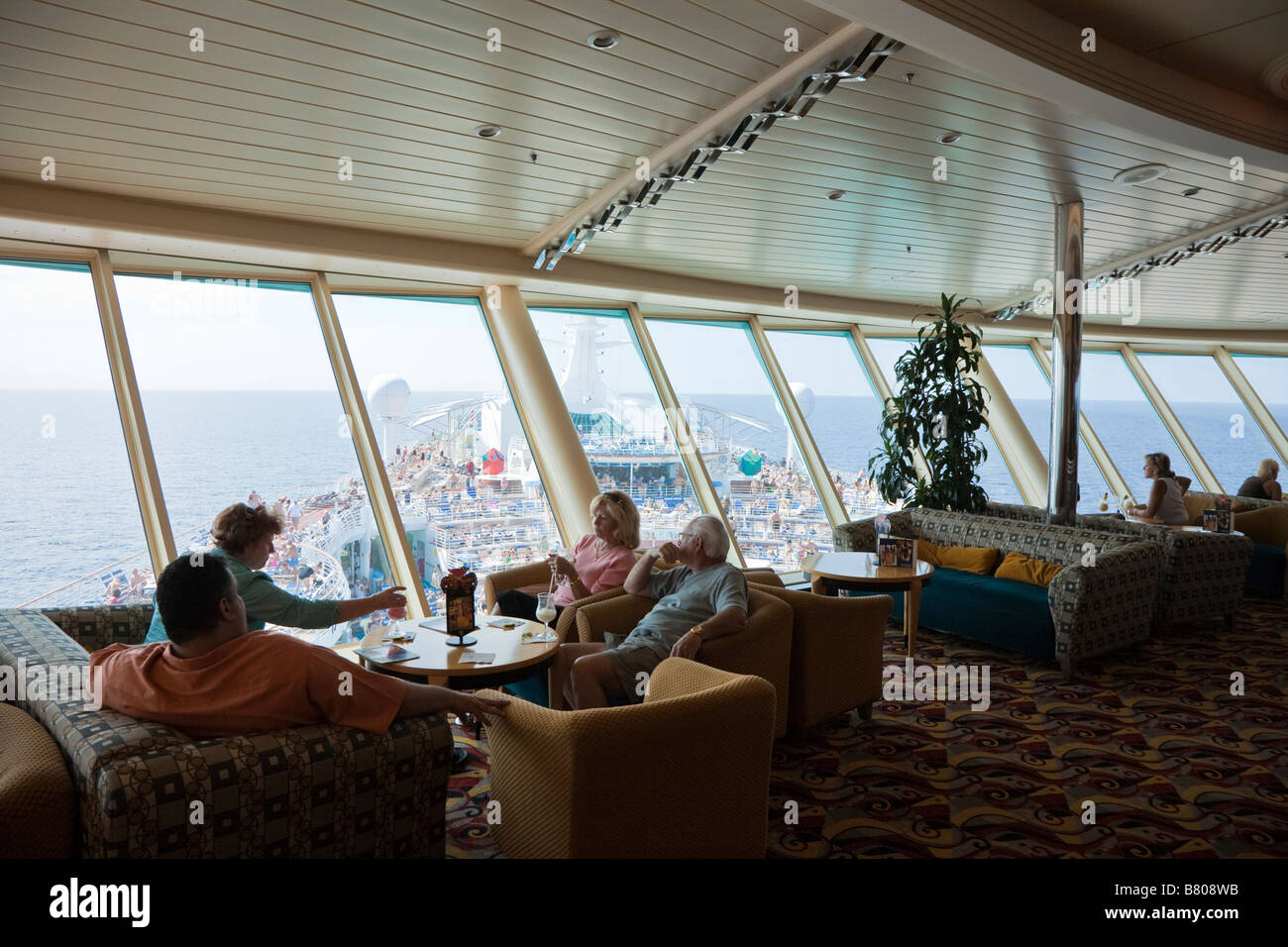 Cruise guests in elevated bar overlooking deck of Royal Caribbean ...