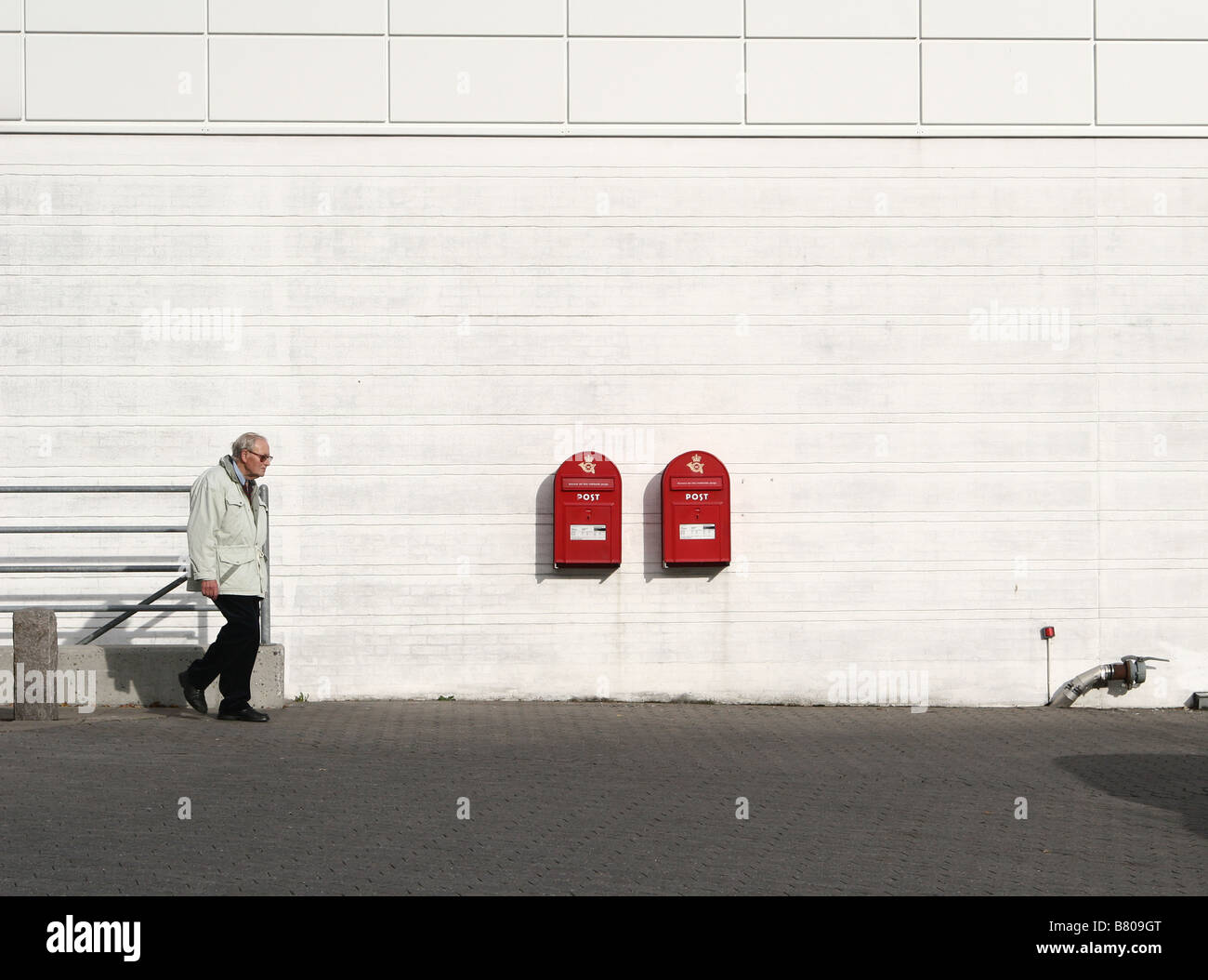 Man in front of a white wall with post boxes in Copenhagen denmark ...