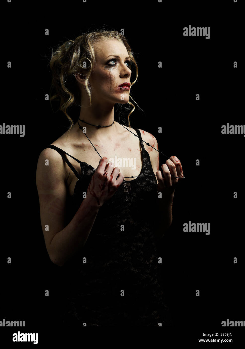 A portrait of a traumatized, derranged woman with blood covered hands ...