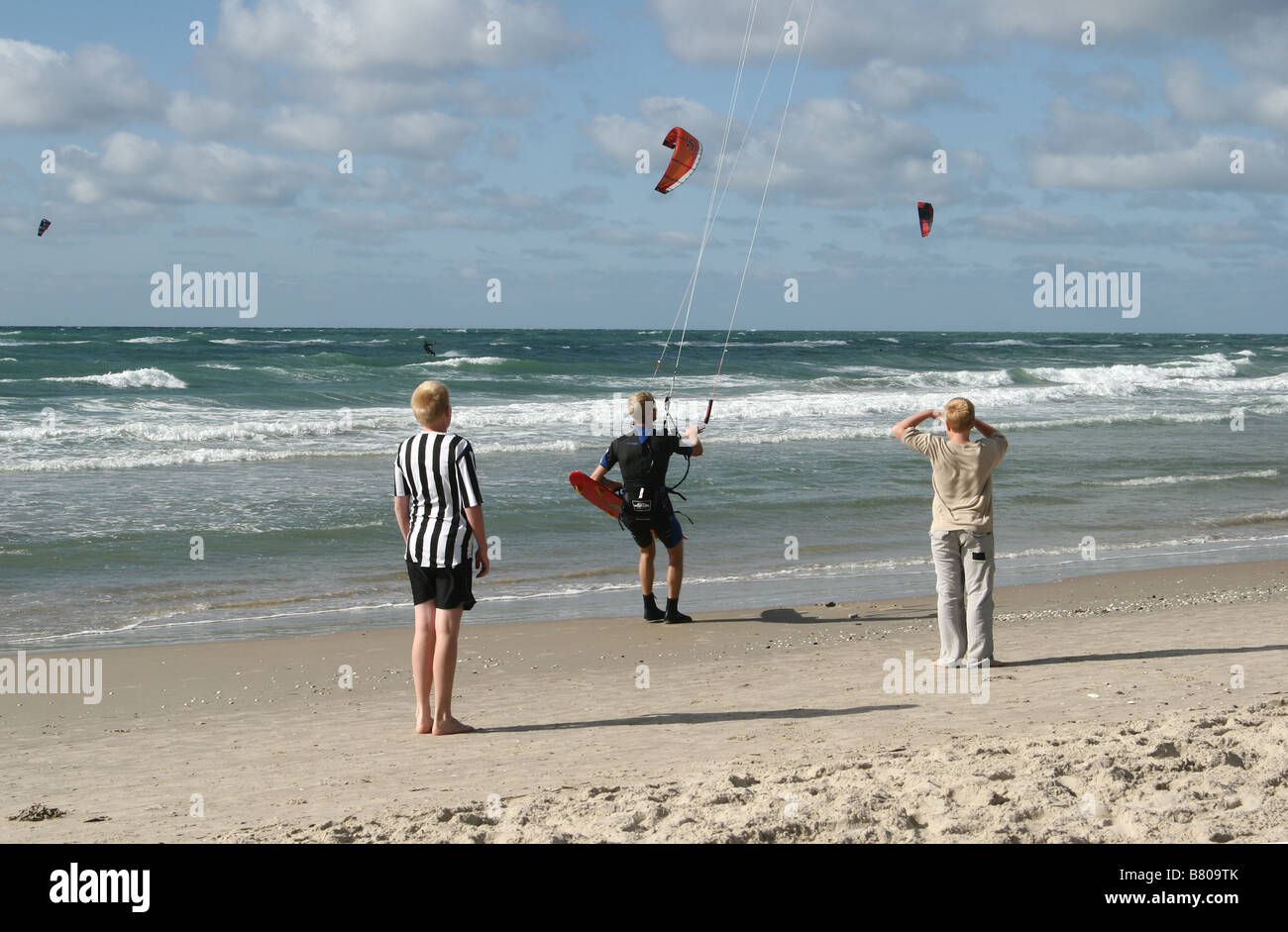 Tourists on the beach in Denmark (west coast in Loekken) Kite surfing ...