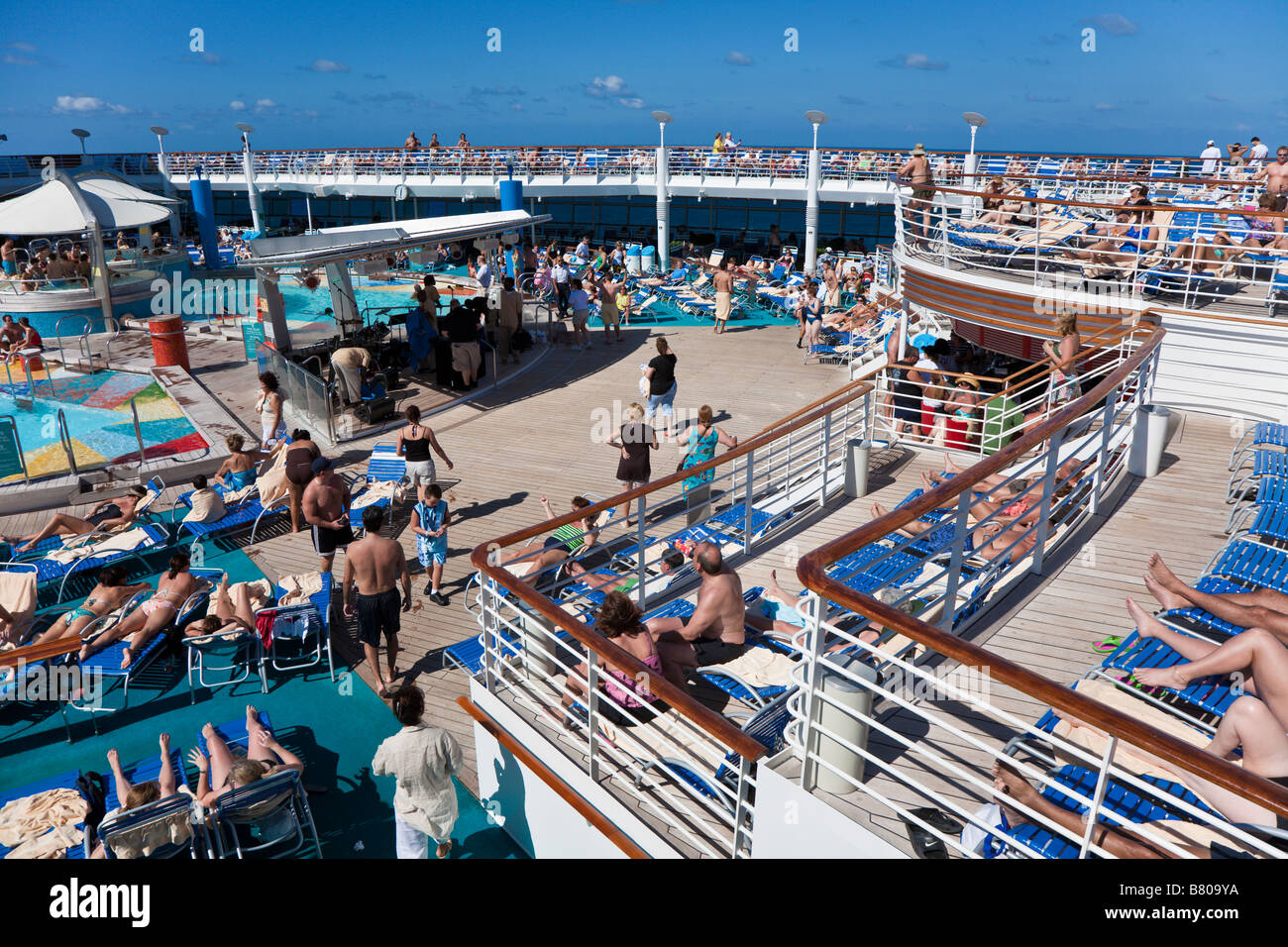 Cruise ship passengers lounging on the sun deck around the pool on ...