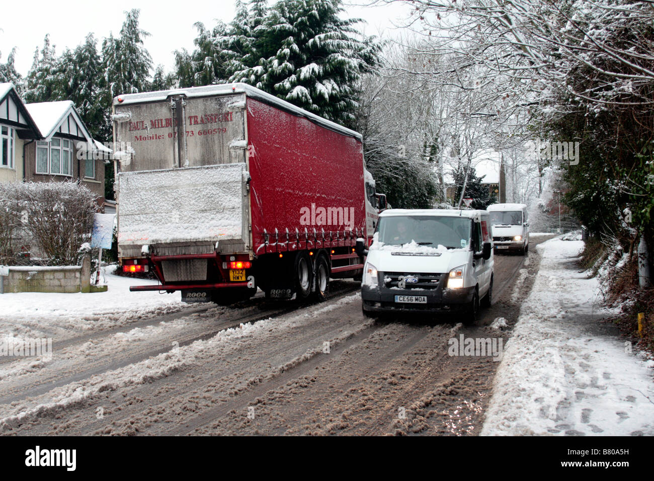 Two vans and a lorry ravel along a snow covered road in Frome, Somerset ...