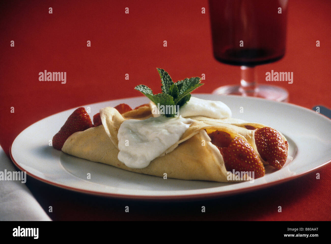 Strawberry filled crepes topped with whipped cream Stock Photo - Alamy